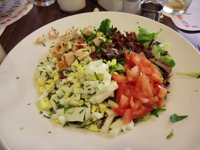 A Cobb salad arranged with such precision it could hang in a modern art museum. Protein, vegetables, and satisfaction in every bite.