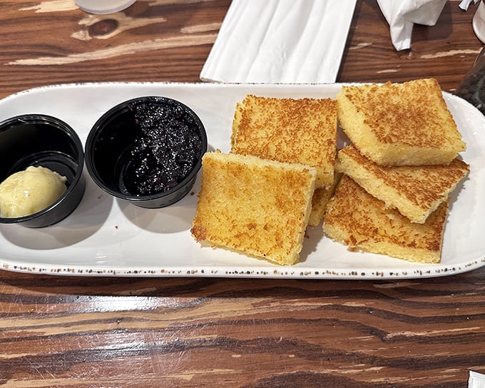 Golden cornbread squares that hover between cake and bread, served with butter and jam that transform the humble into the heavenly. Simple perfection needs no explanation.