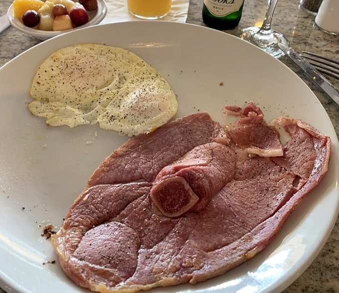 The namesake dish delivers: country ham sliced thin, eggs sunny-side up, and a side of fruit that technically makes this "balanced." Your cardiologist doesn't need to know everything.