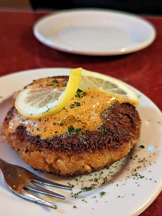 Golden-brown perfection meets the plate in this crab cake, where the crispy exterior gives way to sweet crab meat enhanced by a bright lemon accent.