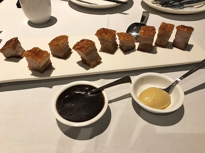 Crispy pork belly squares lined up like delicious dominoes, with dipping sauces standing by for their supporting role in this flavor production.