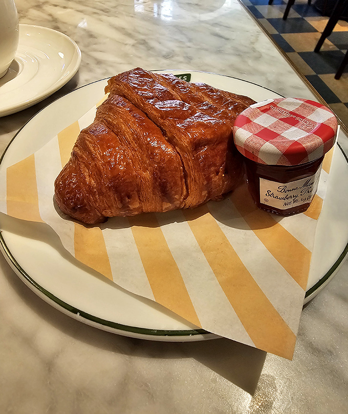 A croissant so perfectly laminated it could be in a French pastry museum, paired with jam that makes supermarket varieties weep with inadequacy.