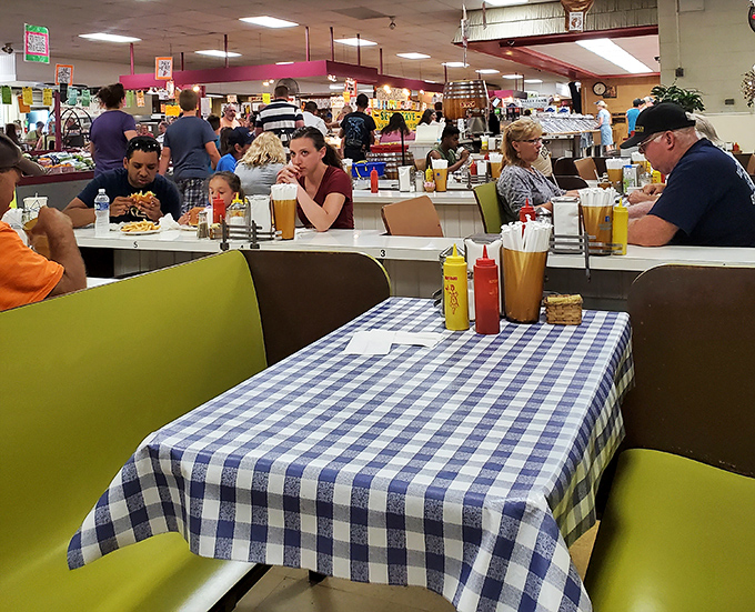 The food court's blue-checkered tablecloths and squeeze bottles of ketchup promise simple pleasures and hearty portions after a morning of serious shopping.