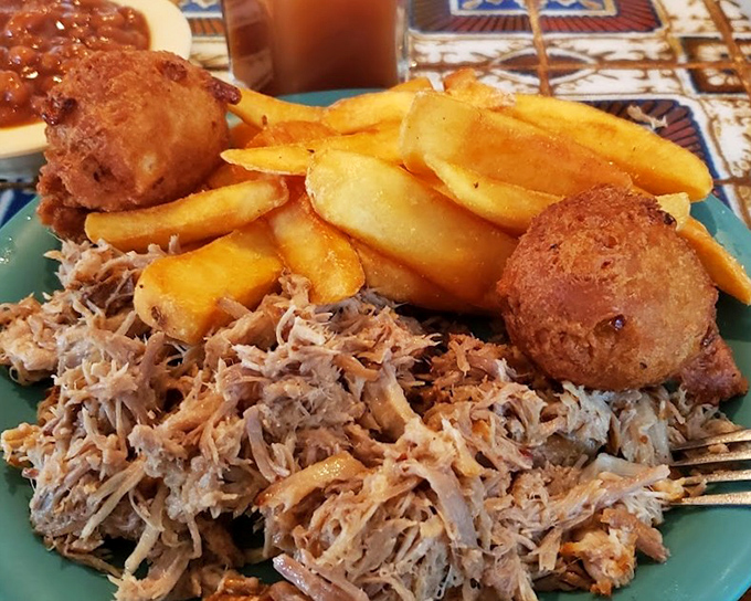 The holy trinity of Southern comfort: perfectly pulled pork, creamy coleslaw, and beans that have clearly been simmering since sunrise.