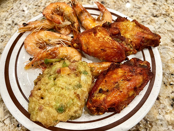The holy trinity of buffet indulgence: plump shrimp, crispy chicken wings, and savory egg foo young that would make your takeout place jealous.