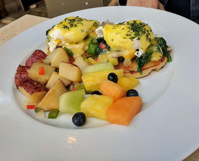 Eggs Benedict that would make a Parisian chef nod in approval, paired with a rainbow of fresh fruit that brightens both the plate and your morning.