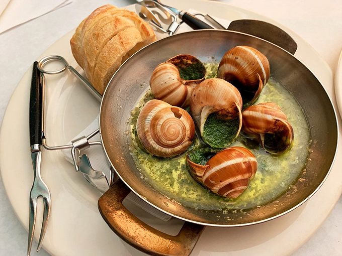 Escargot swimming in garlic butter&mdash;proof that anything becomes delicious when given the French treatment. That baguette isn't just a side, it's an essential butter-delivery system.