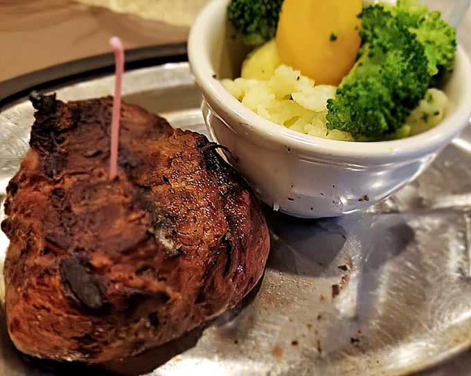 The filet mignon sits regally on its silver throne, accompanied by vegetables that know their supporting role in this beef ballet.