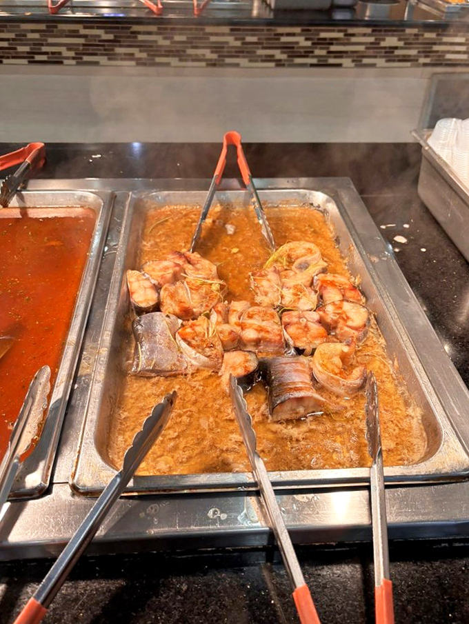 These simmering treasures from the deep await your selection. The tongs are your ticket to seafood nirvana.