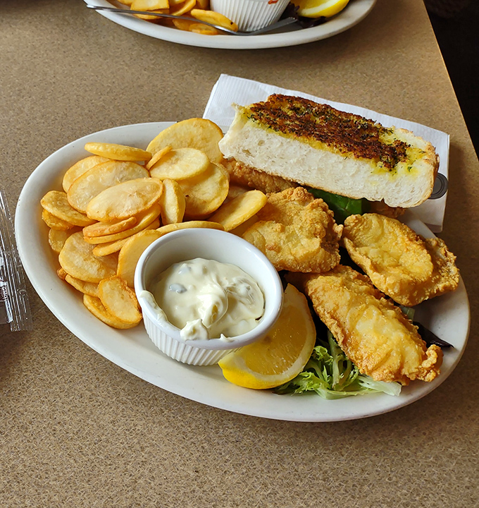 Fish and chips with a side of garlic bread&mdash;the holy trinity of coastal comfort food, executed with the precision of a culinary love letter.