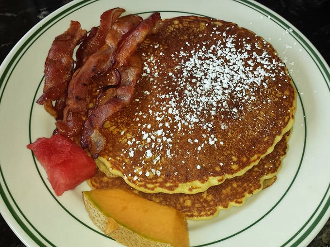Pancakes so fluffy they practically hover above the plate. That powdered sugar snowfall is just showing off.
