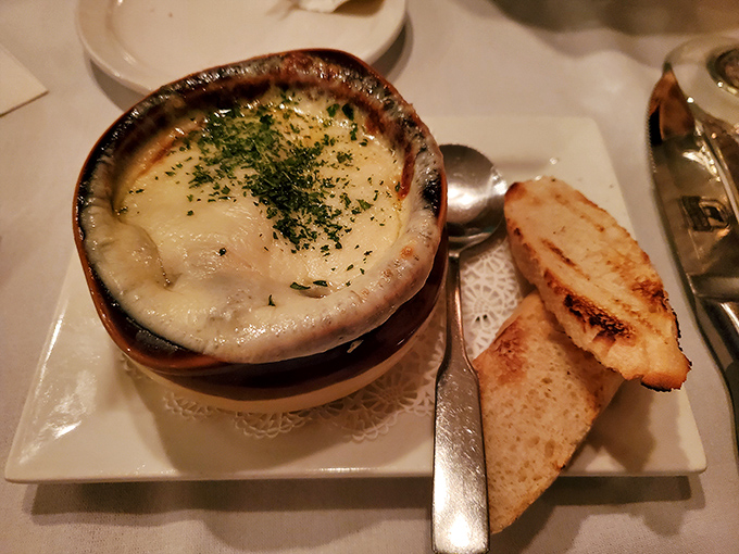 The French onion soup arrives with a blanket of melted cheese that should be illegal in at least seven states.