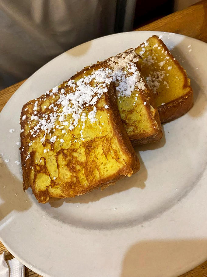 French toast that's achieved the impossible trifecta: golden exterior, custardy interior, and enough powdered sugar to make your dentist wince.