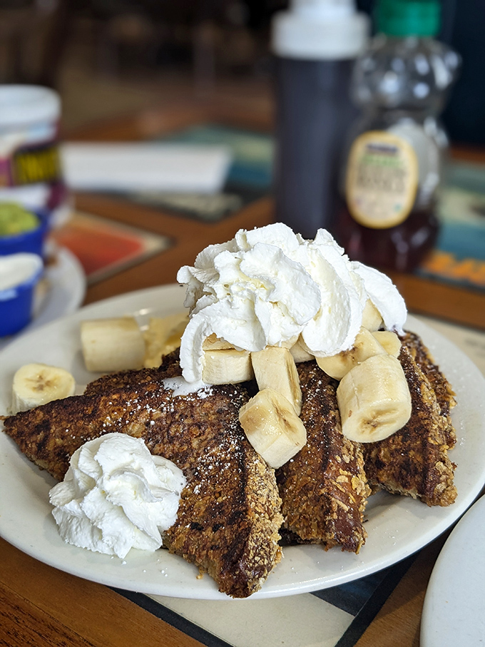 French toast that's having an identity crisis as a dessert, topped with enough whipped cream and bananas to make Elvis jealous.