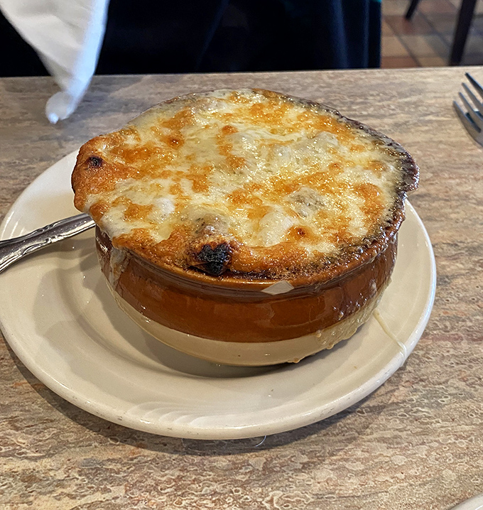 French onion soup that's worth the cheese-pull photo op—a bubbling cauldron of comfort topped with a bronzed cheese roof.