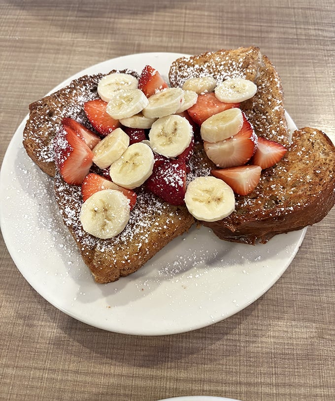 French toast that makes ordinary bread feel inadequate. Topped with fresh fruit and a dusting of powdered sugar, it's breakfast that doubles as dessert.