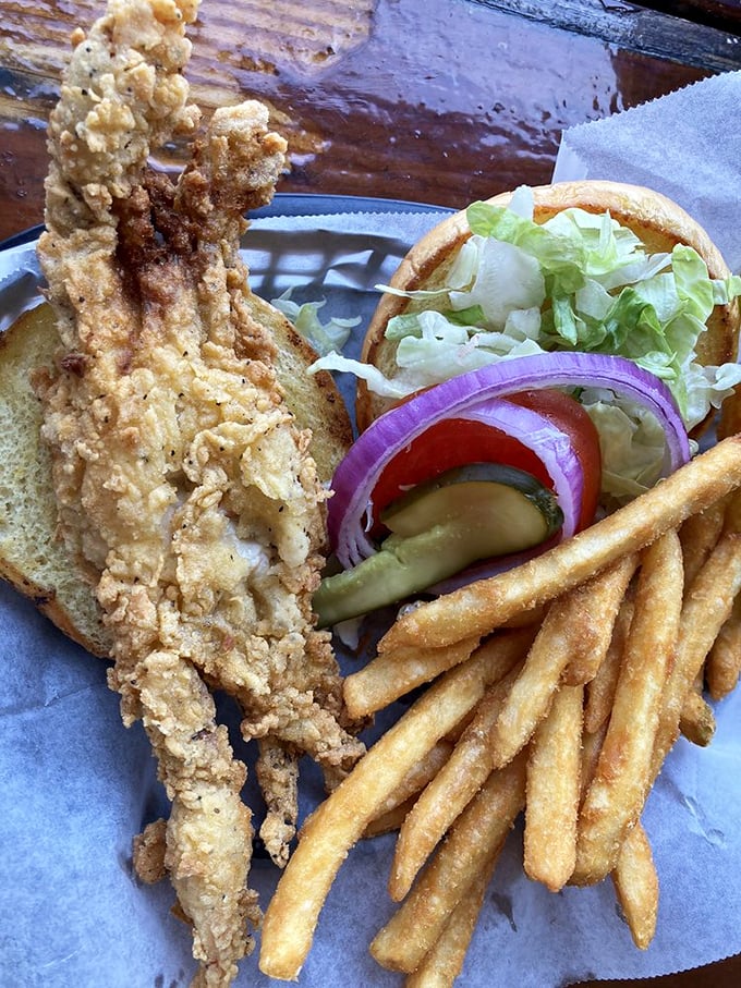 This isn't just a sandwich; it's a masterclass in seafood simplicity&mdash;crispy soft-shell crab on fresh bread with classic fixings and golden fries.
