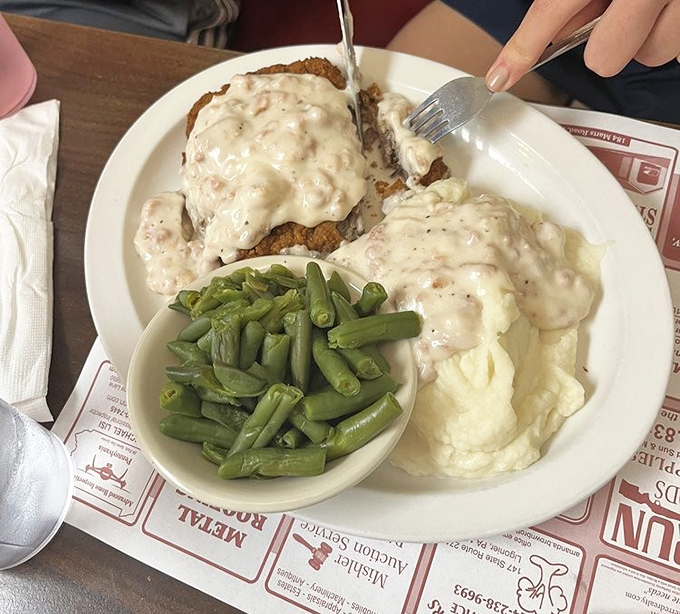 Country fried steak smothered in peppery gravy with green beans on the side&mdash;a plate that whispers "nap time" before you've even finished.