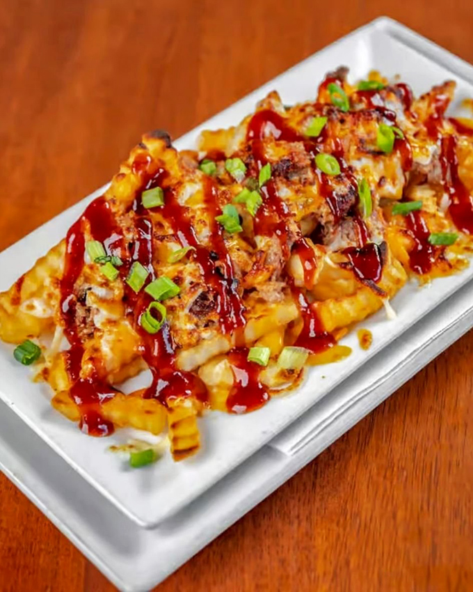 These loaded fries aren't just a side dish, they're a main event &ndash; draped in cheese, BBQ sauce, and green onions like a culinary red carpet.