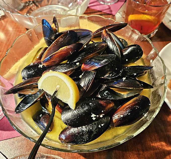 Mussels bathed in garlic white wine sauce &ndash; like tiny ocean treasures that decided to vacation in butter and lemon.