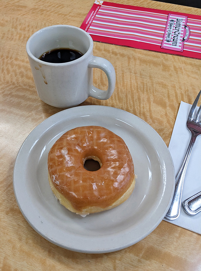 The glazed donut and coffee combo&mdash;civilization's most perfect pairing since Fred and Ginger, displayed on a diner plate that's seen thousands of happy mornings.