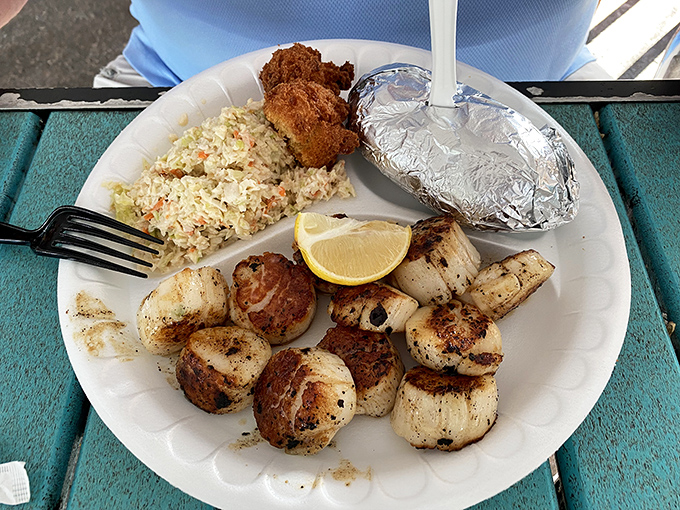 Perfectly seared scallops surrounded by rice and hush puppies. The caramelized edges tell you everything you need to know about the kitchen's skill.