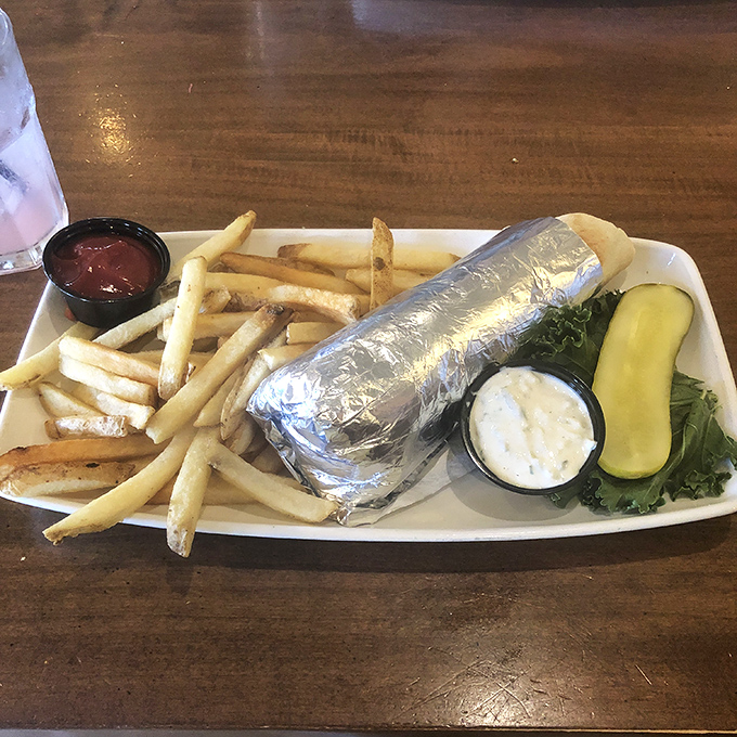 When your sandwich arrives wrapped like a present, you know you're in for something special. Those fries aren't just sides&mdash;they're co-stars.