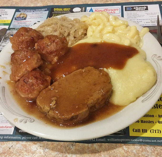 The holy trinity of Pennsylvania Dutch comfort: meatloaf, mac and cheese, and sauerkraut, all sharing one harmonious plate.