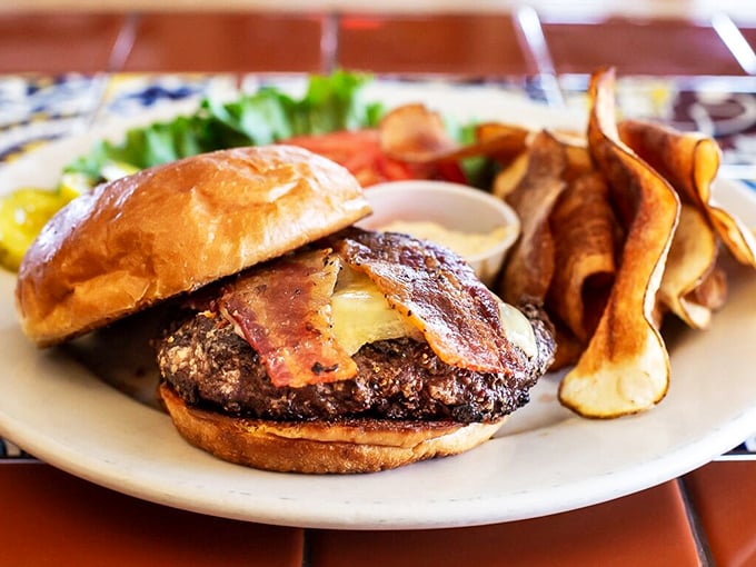 A burger that means business—hand-formed patty, melty cheese, and bacon on a toasted bun with house-made chips that shatter like glass.