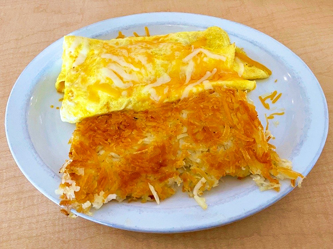 An omelet that's more gold than Fort Knox, paired with hash browns so perfectly crisp they deserve their own fan club.