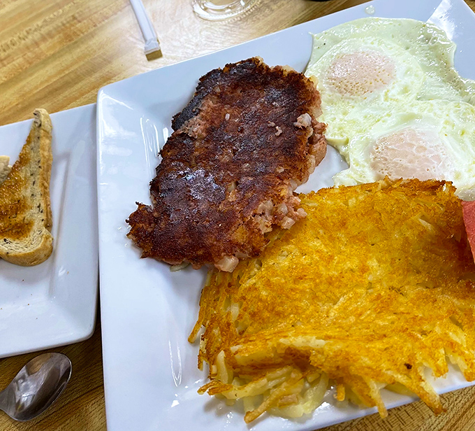 The breakfast trinity: perfectly seared hash browns, eggs with just-right yolks, and a protein sidekick. Morning harmony achieved.