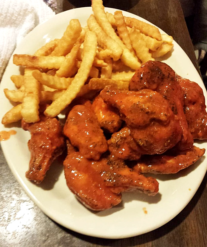 These buffalo wings arrive glistening with sauce, ready to test your heat tolerance and napkin supply simultaneously.