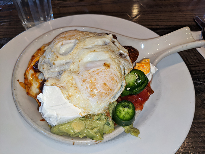Breakfast with attitude: eggs perched proudly atop a fiesta of flavors, with jalape&ntilde;os standing guard and avocado cooling things down.