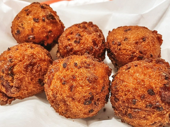 Hushpuppies so perfectly golden they should be in a museum, except museums don't let you dunk exhibits in honey butter.