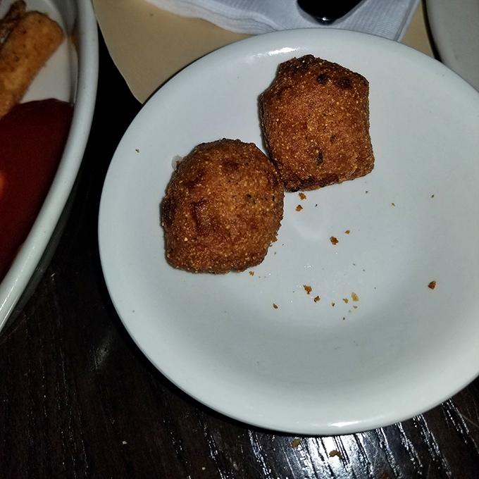 Hush puppies so perfectly golden they deserve their own spotlight. Two bites of cornmeal bliss that whisper, "Order another round."
