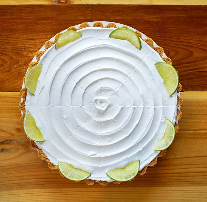 Key lime pie with a spiral of whipped cream so precise it could qualify as art. The lime wedges aren't just garnish&mdash;they're a promise of tangy perfection.