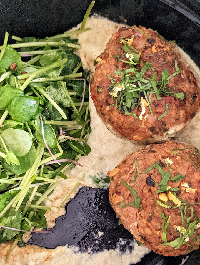 Lamb meatballs that could make a Greek grandmother weep with joy. Nestled on creamy hummus with fresh greens &ndash; comfort food with a college degree.