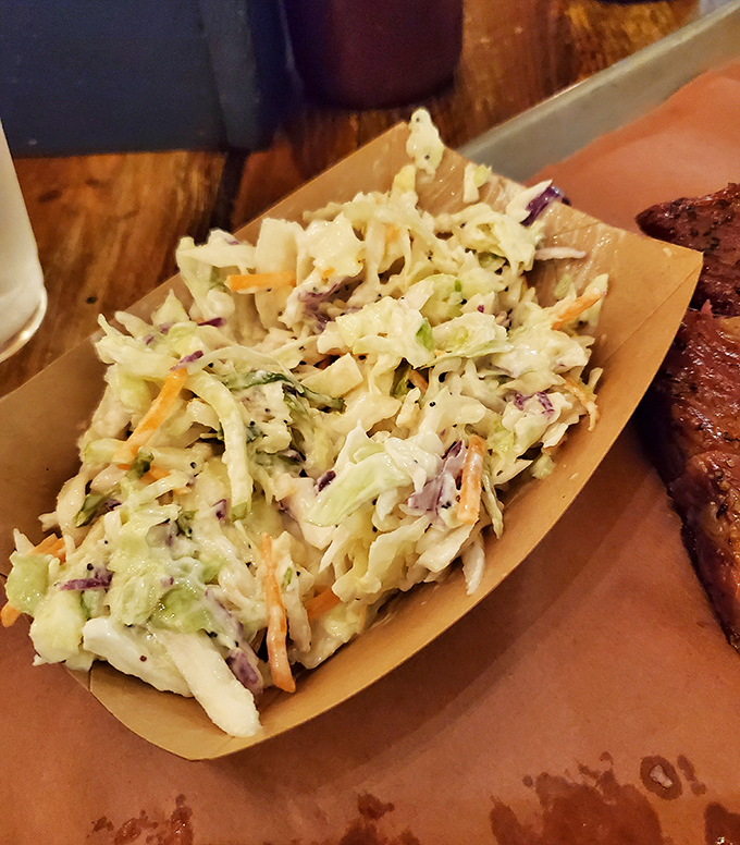 Not just any coleslaw &ndash; lemon poppyseed coleslaw. The bright, crunchy counterpoint that cuts through rich BBQ like a well-timed punchline.