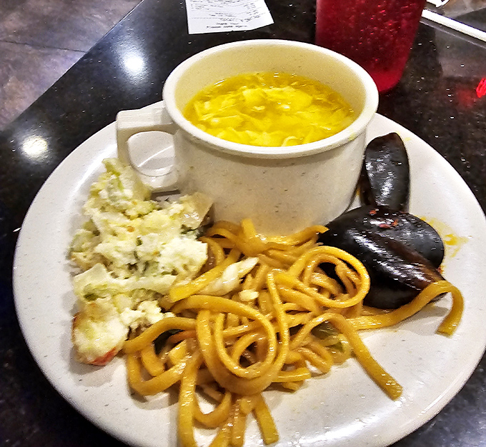 A buffet plate that tells the whole story: golden egg drop soup, twirling lo mein noodles, and those mysterious black mushrooms that always seem worth the adventure.