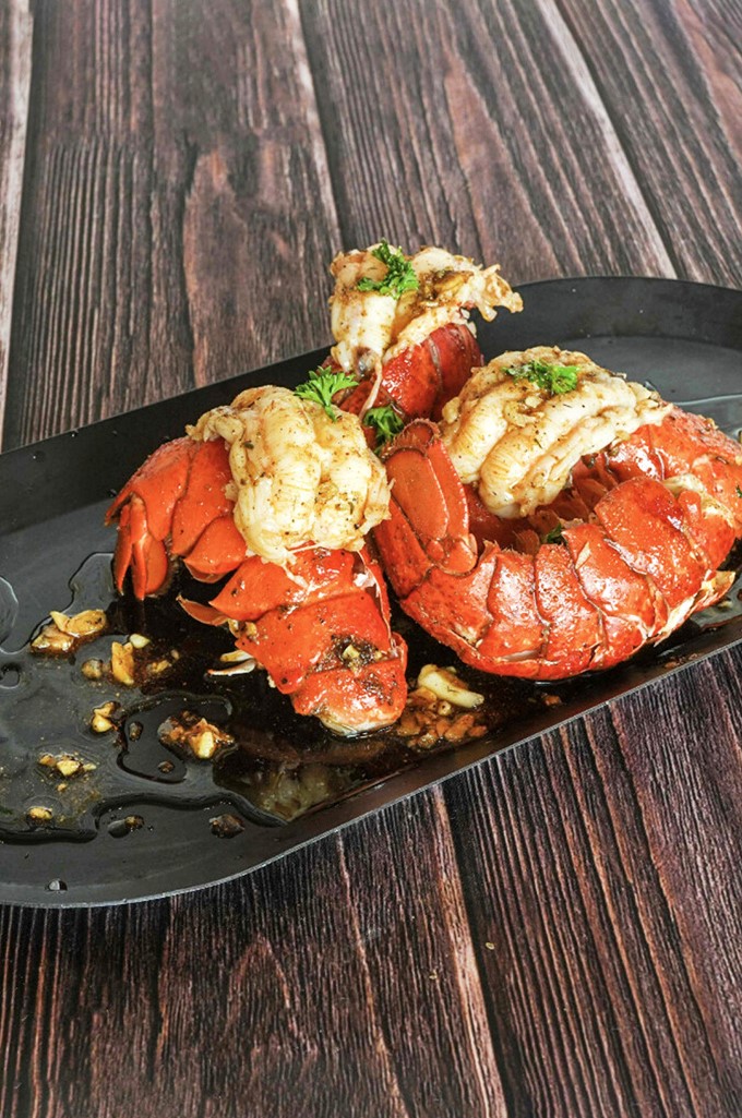 Lobster tails that look like they're posing for their seafood glamour shot. The garlic butter sauce is practically begging to be the star of your food dreams.