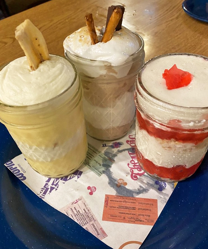 Three mason jar desserts lined up like sweet soldiers, each one a different delicious adventure waiting.