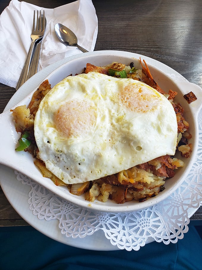 Breakfast skillet perfection: crispy potatoes, savory meats, and eggs with yolks so perfectly sunny they could brighten even a Monday morning.