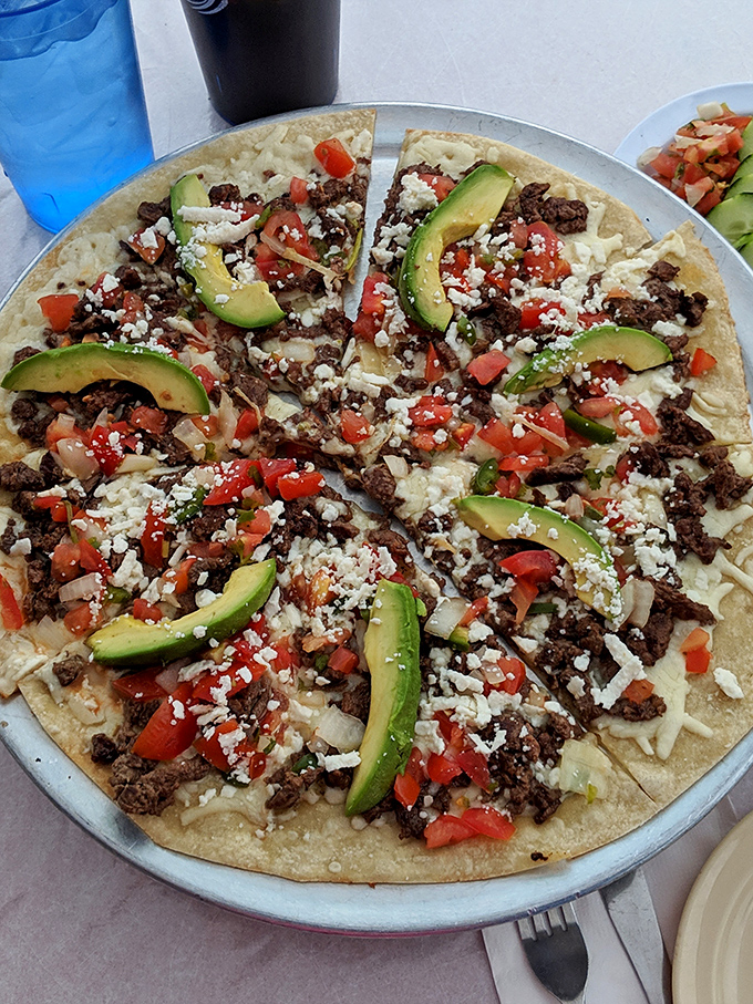 Not your chain restaurant Mexican pizza. This beauty, topped with fresh avocado and crumbled cheese, makes franchise versions look like sad cardboard imposters.