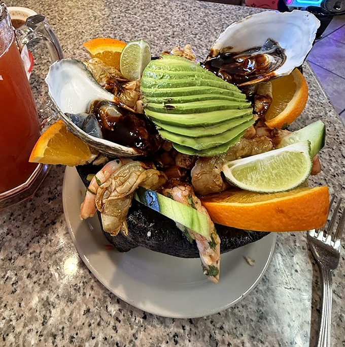 The molcajete seafood feast arrives like Neptune's personal treasure chest. That perfectly sliced avocado is the crown jewel.