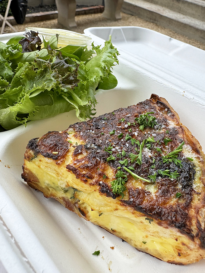 A slice of quiche that makes you question why anyone would ever skip breakfast, with a side salad that doesn't feel like an afterthought.