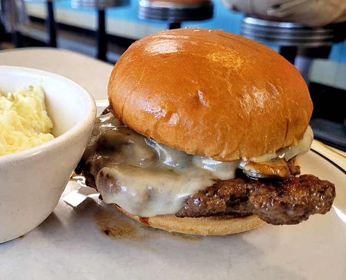 Behold the cheeseburger in its natural habitat—juicy, melty, and utterly magnificent. This isn't fast food; it's slow food done right.