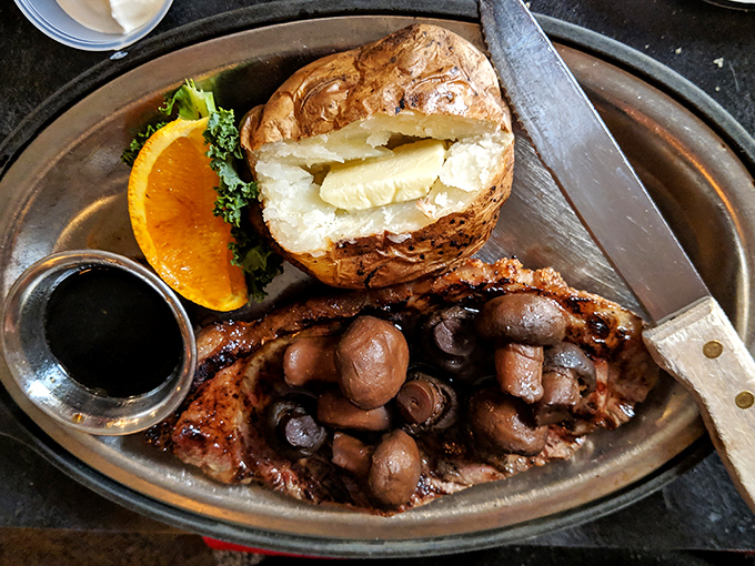 A baked potato that's dressed better than most people at formal events, alongside a steak and mushrooms that make you wonder why you'd ever eat anything else.