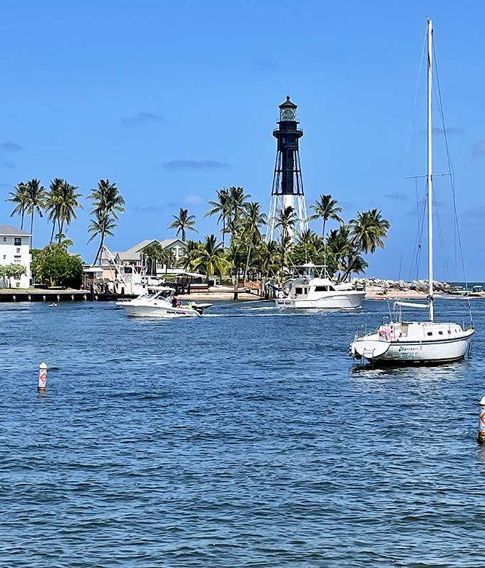 A postcard come to life &ndash; the lighthouse stands proudly among palm trees and boats, the quintessential Florida maritime scene.