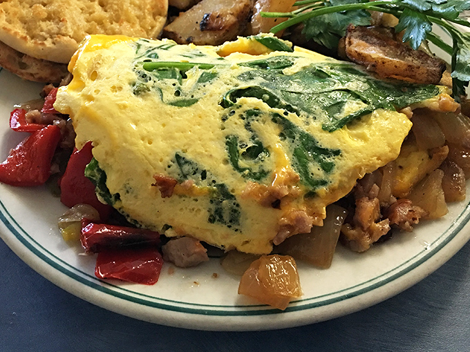 An omelet that's practically architectural—layers of vibrant vegetables and melted cheese folded into fluffy eggs. Breakfast engineering at its finest.