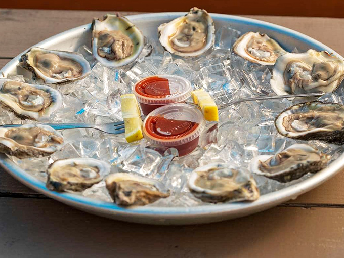 A dozen glistening oysters on ice—nature's perfect appetizer. Each briny morsel tells a story of the waters just beyond the restaurant's deck.